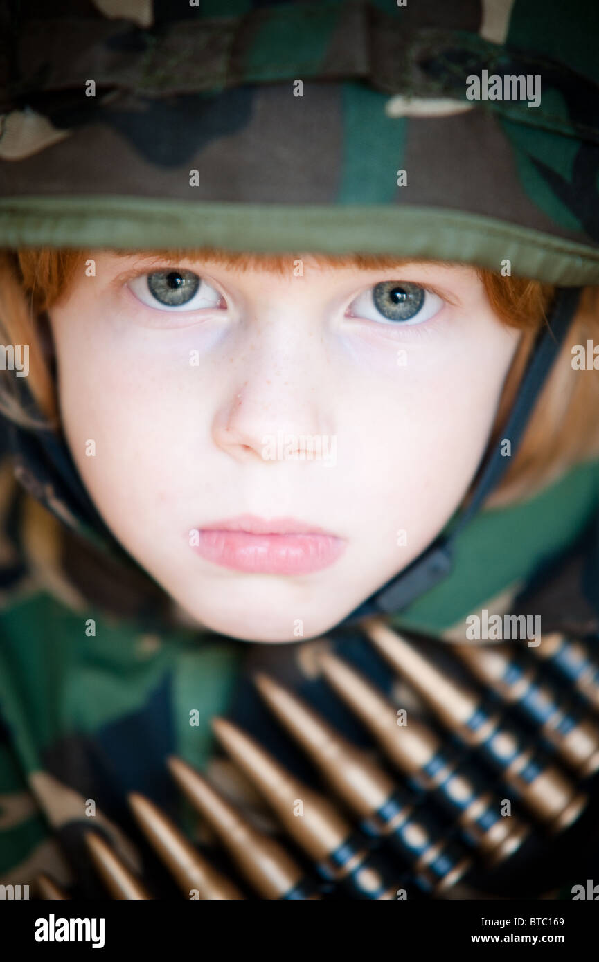A young boy stares out from his camouflage play army uniform Stock ...