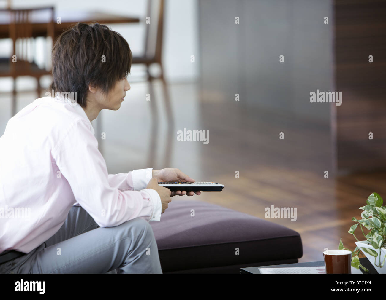 Man using remote control Stock Photo - Alamy