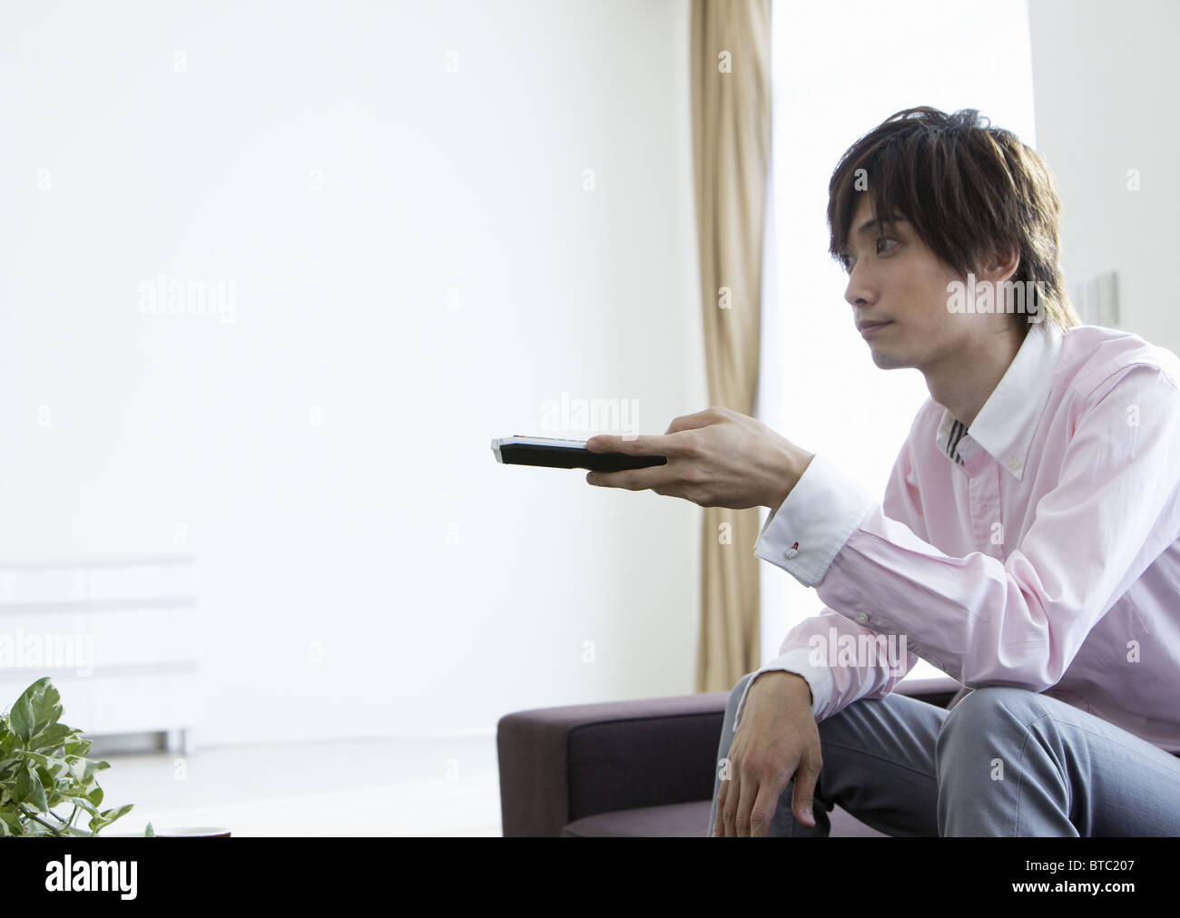 Man using remote control Stock Photo - Alamy