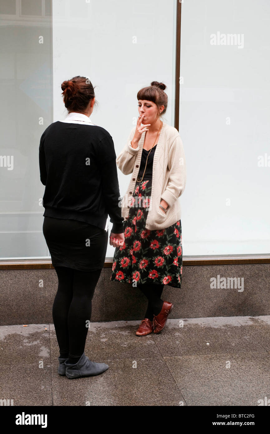 Young women workers taking a smoking break in Central London standing ...