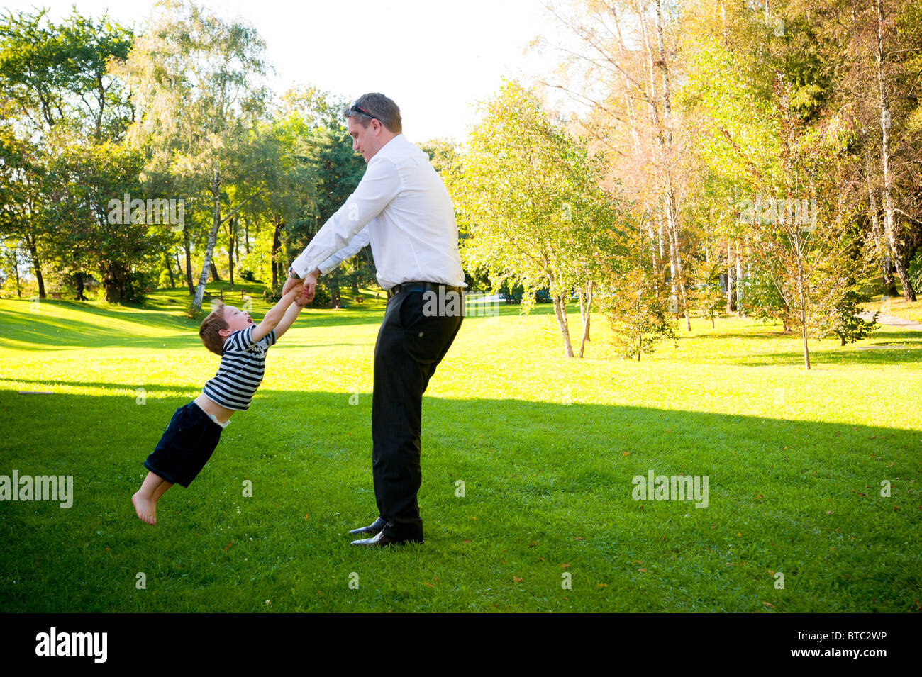 Man spinning around a little boy Stock Photo - Alamy
