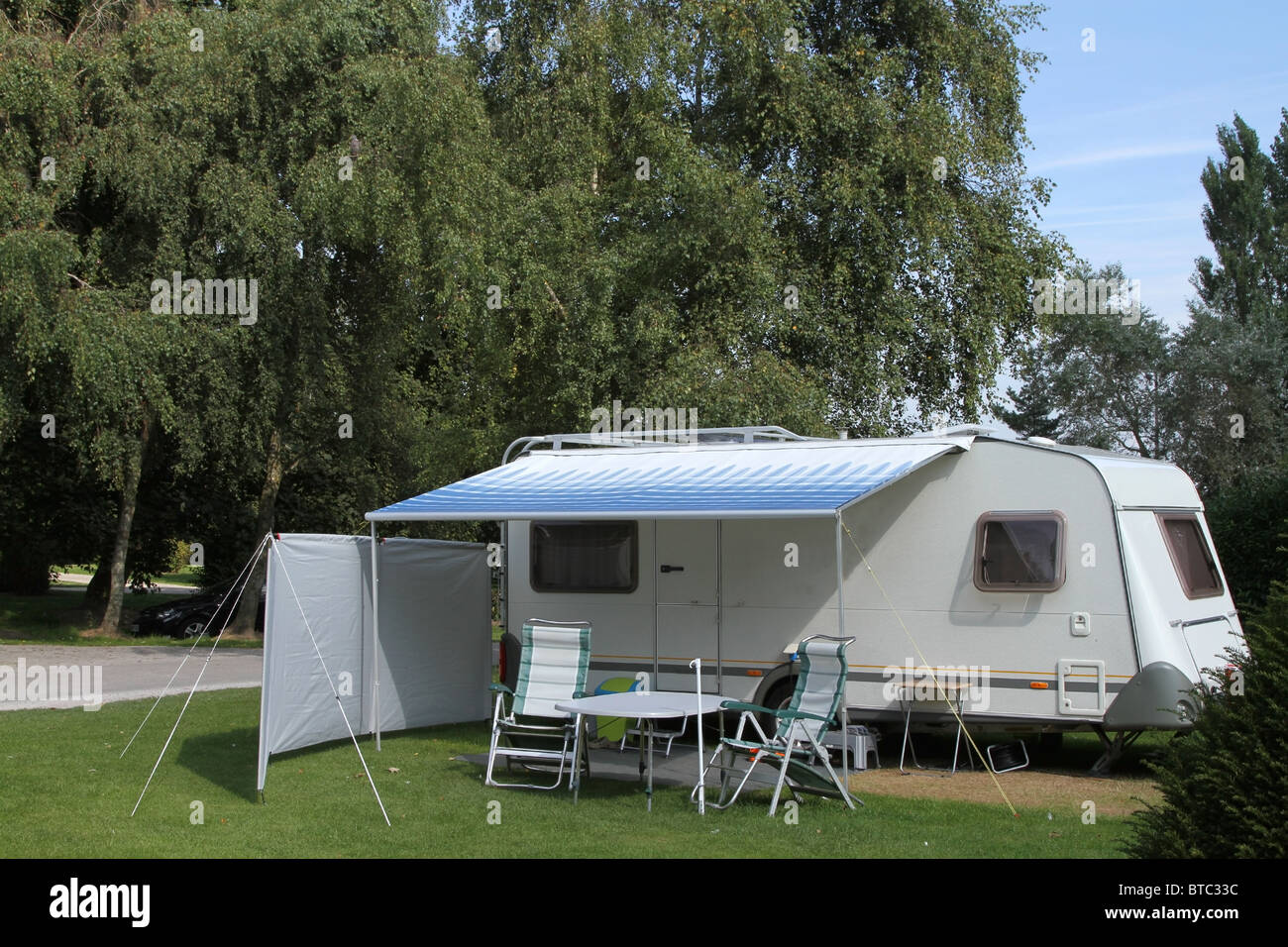 Touring caravan and veranda awning providing shade on a pleasant ...