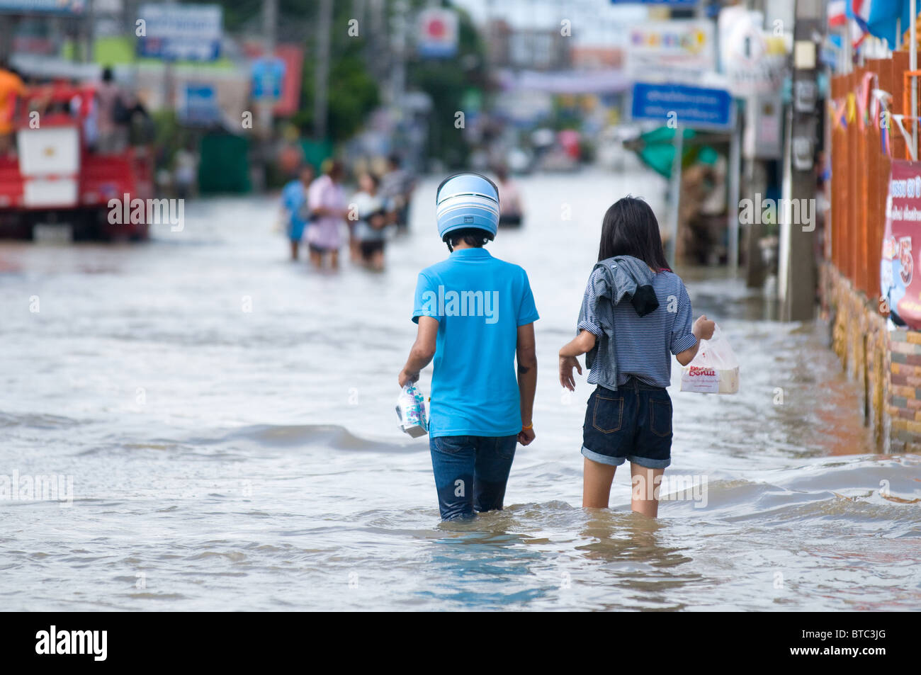 Young couple wading through the streets of the city during the worst ...