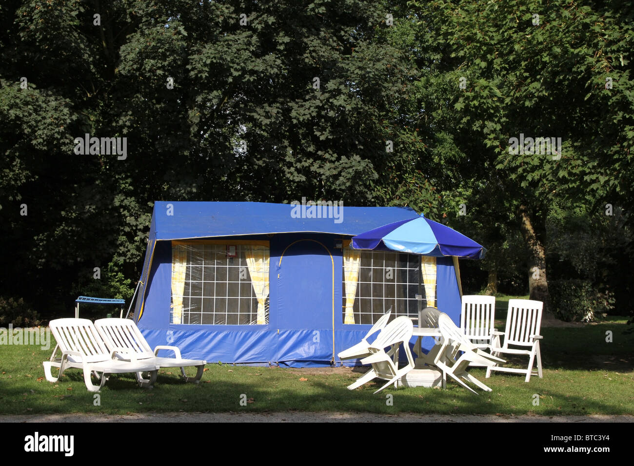 Family frame tent pitched on a woodland camp site, with table and ...