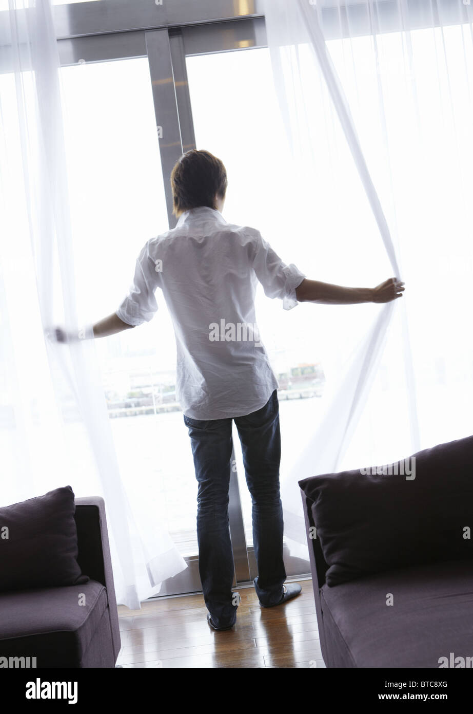 Young man by the window Stock Photo - Alamy