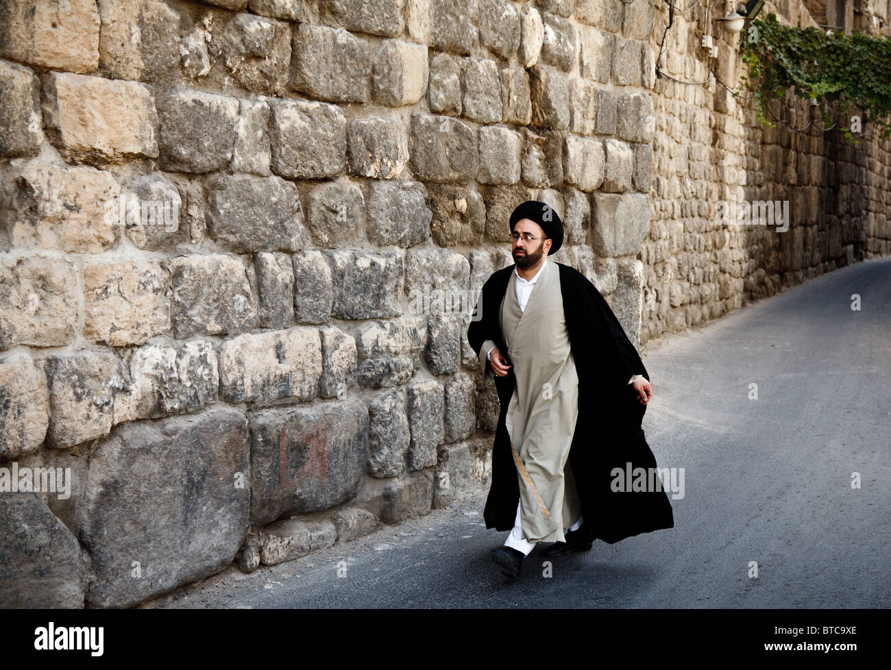 devout Muslim man in traditional costume walking by the walls of the ...