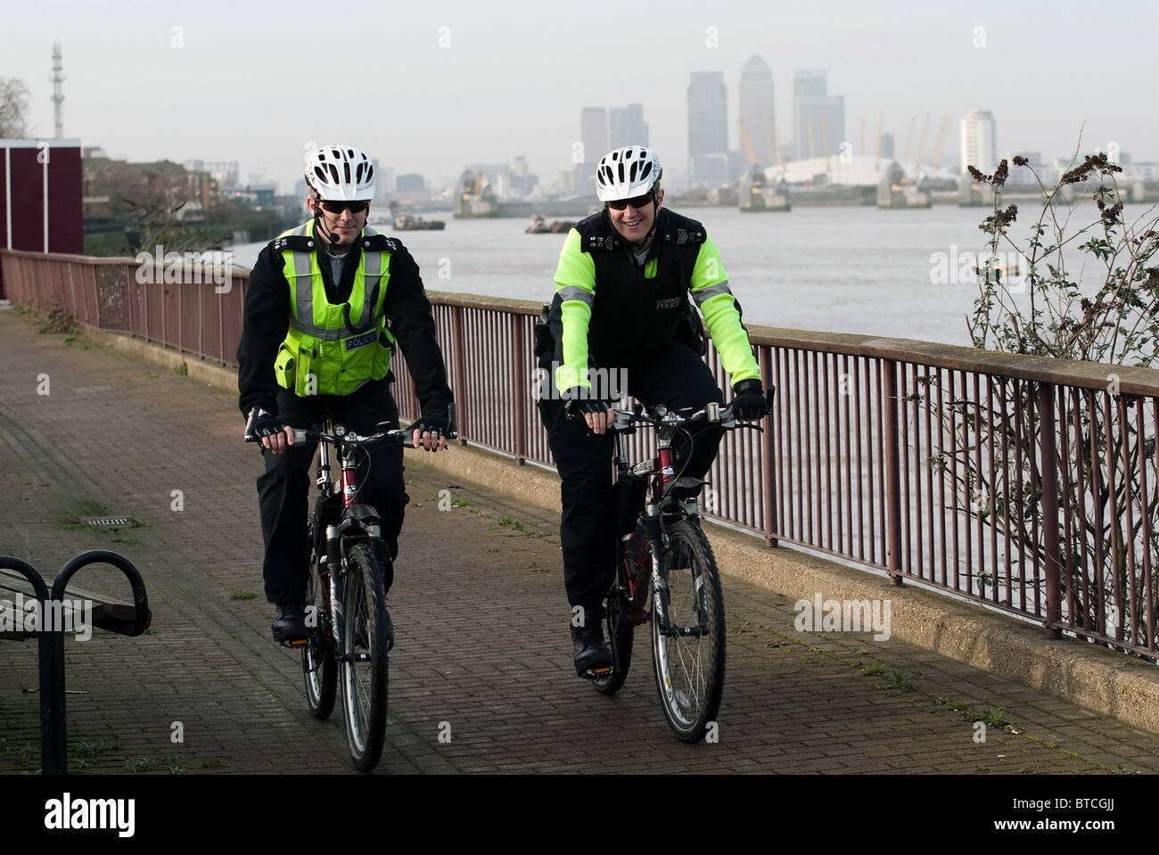 Metropolitan Police constables riding mountain bikes along the banks of ...