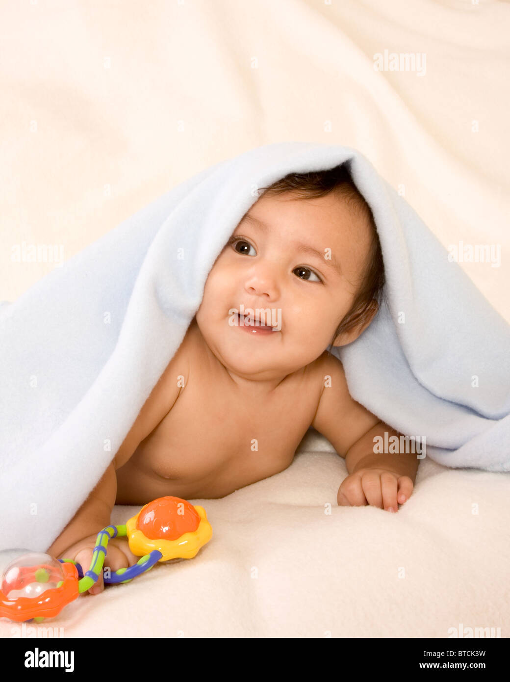 cute kid lying down on his tummy on blanket with stuck out tongue ...