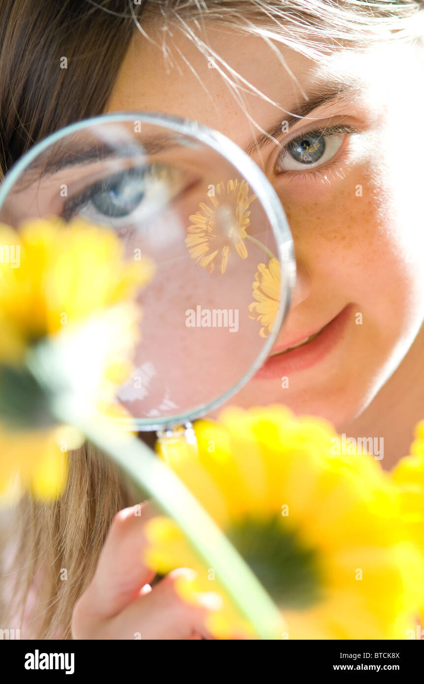young female looking at flower through magnifying glass Stock Photo - Alamy