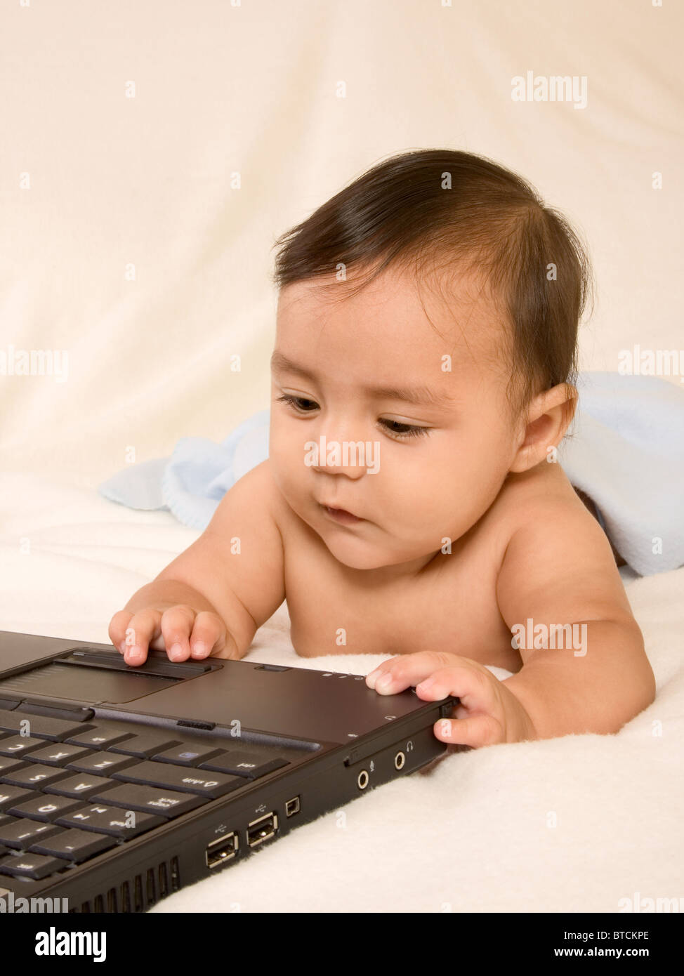 Kid playing with portable computer, surfing net, checking e-mail ...