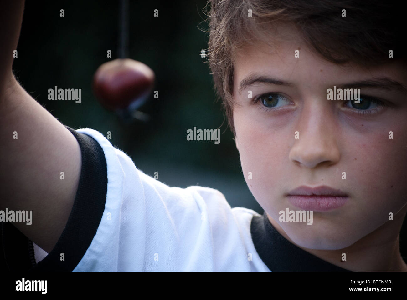 A boy holds a conker on a string for the conker game Stock Photo - Alamy