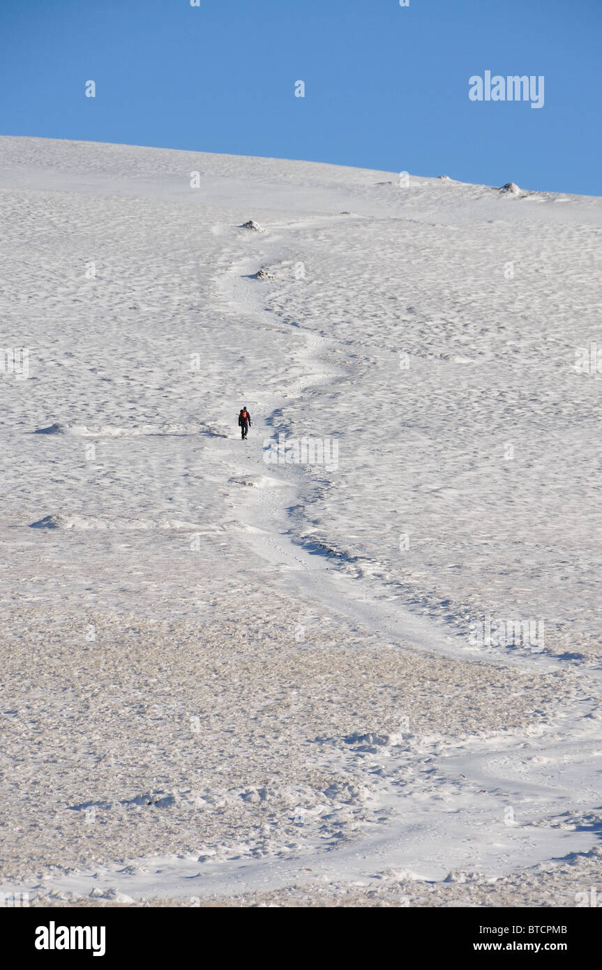 Walker ascending Eel Crag (Crag Hill) in winter in the English Lake ...