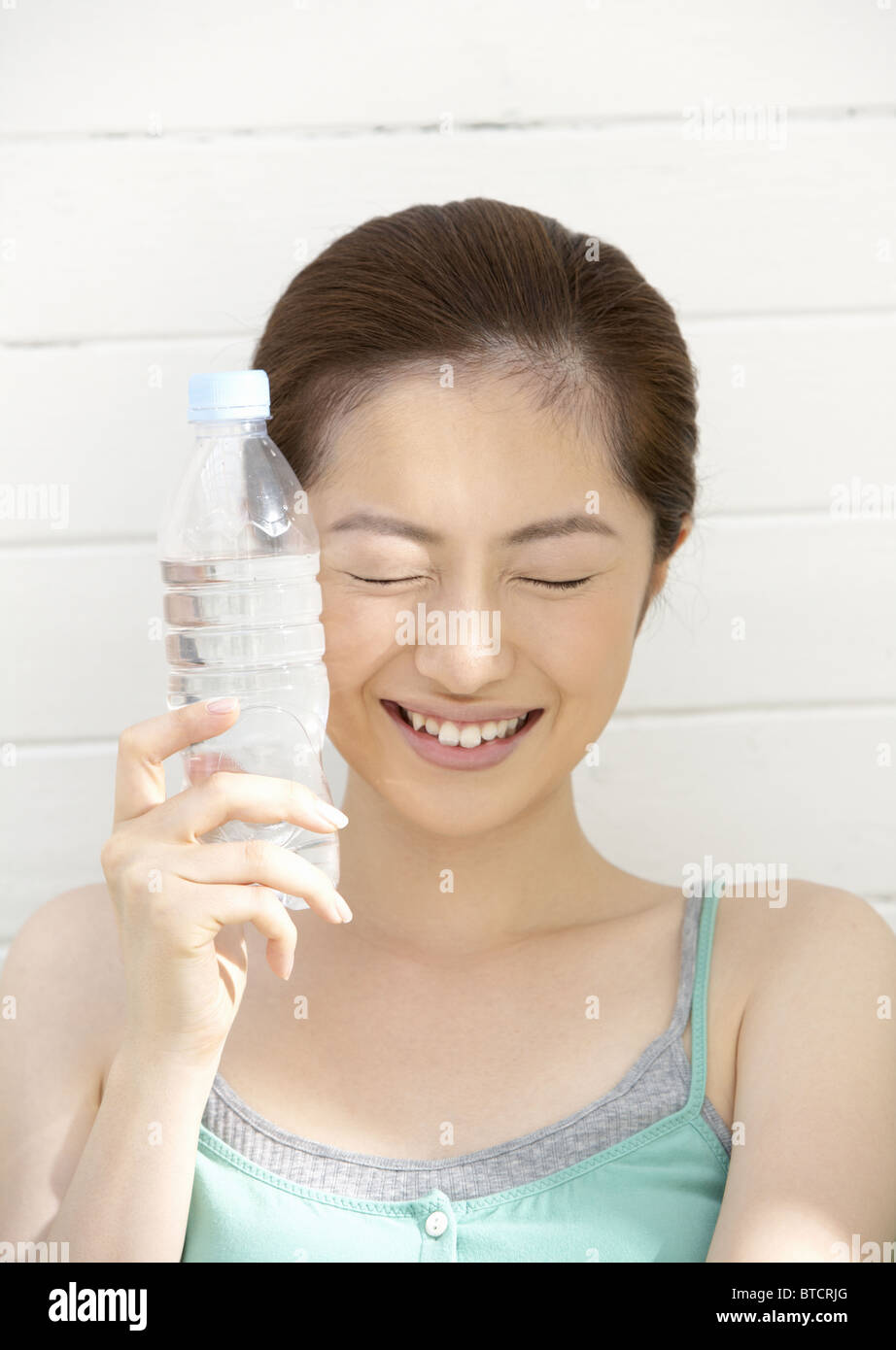 Woman putting plastic bottle on her face Stock Photo - Alamy