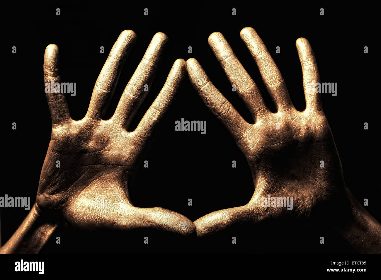 beautiful male hands in gold paint on black background closeup Stock ...