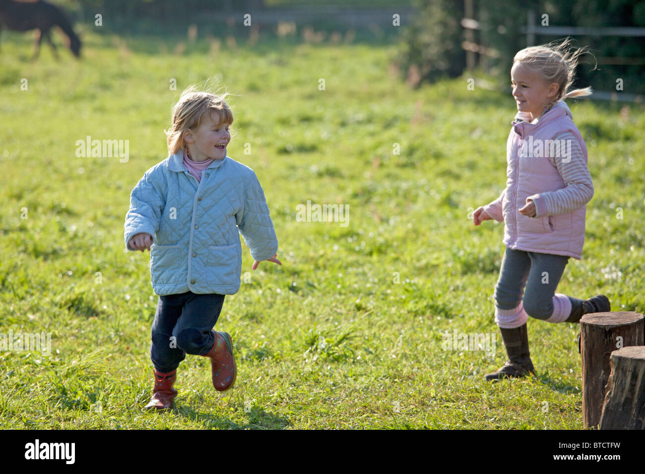 two little girls running across a meadow Stock Photo - Alamy