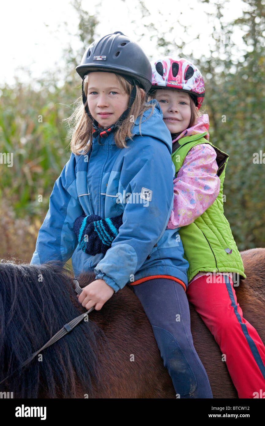 two small girls riding a pony together Stock Photo - Alamy