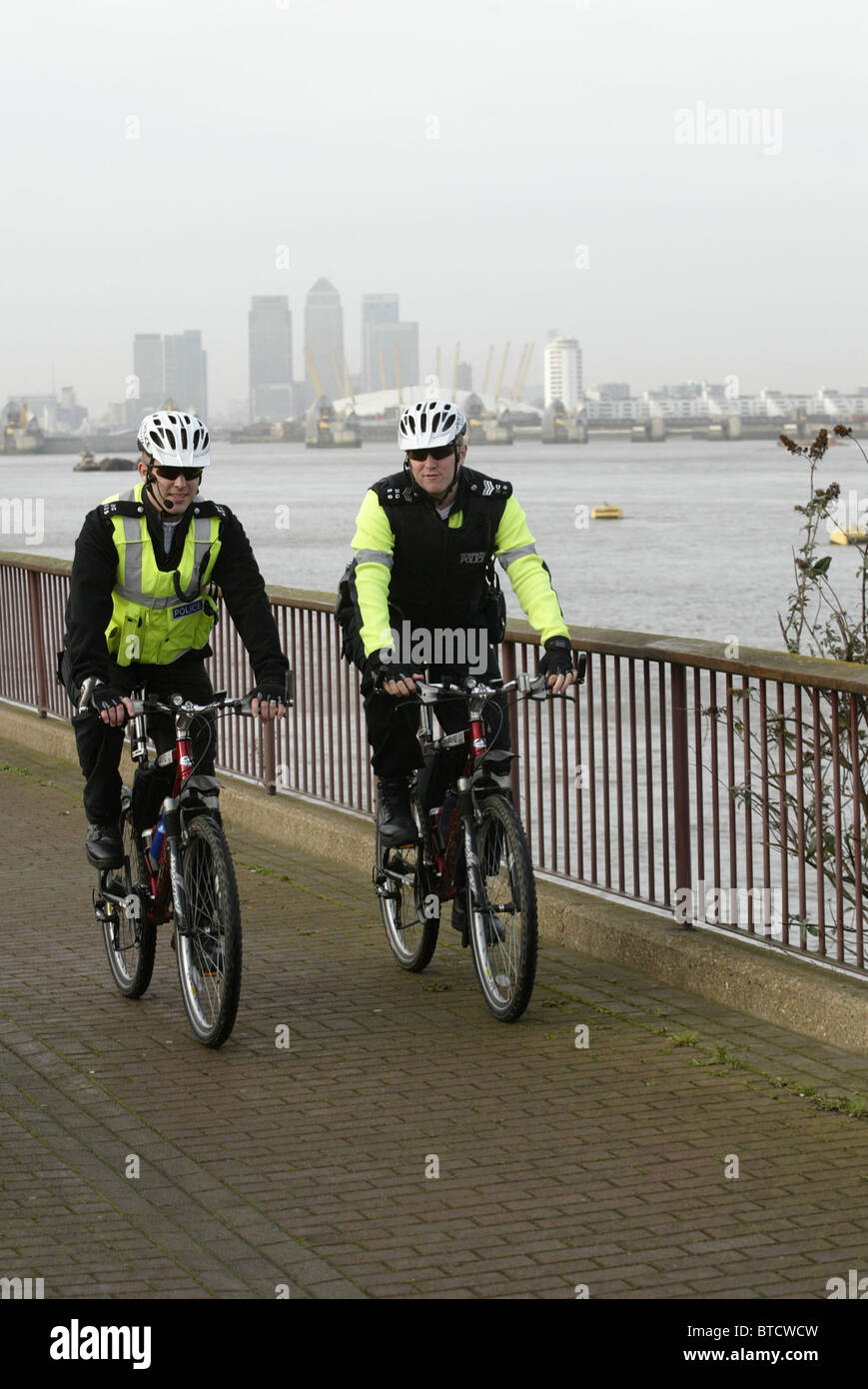 Metropolitan Police constables riding mountain bikes along the banks of ...