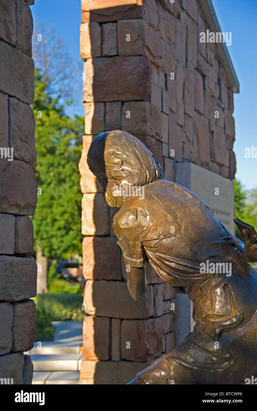 Bronze statue of Anne Frank peering through a window while in hiding at ...