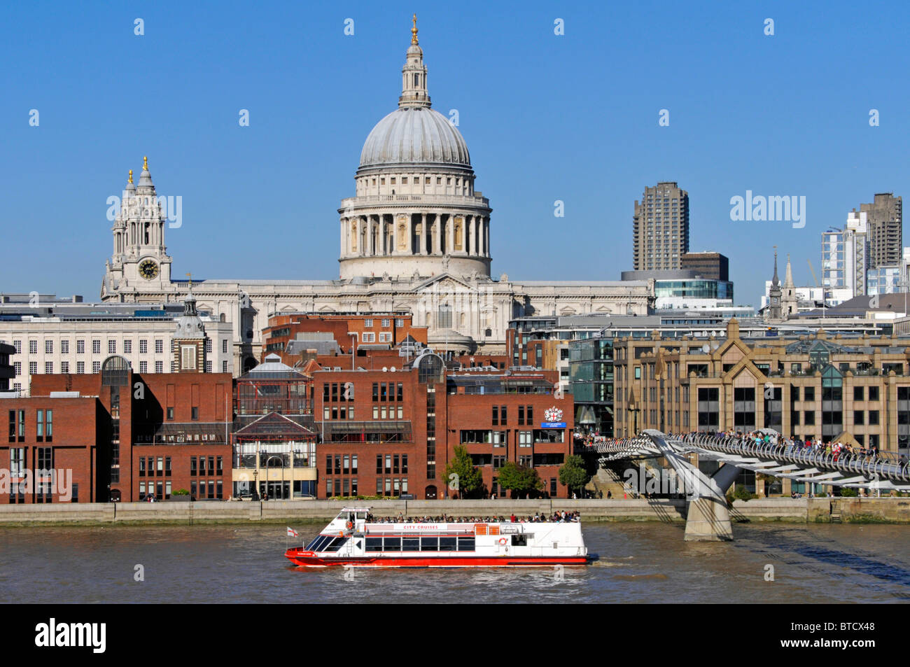 River Thames tour boat passing St Pauls Cathedral and the Millenium ...
