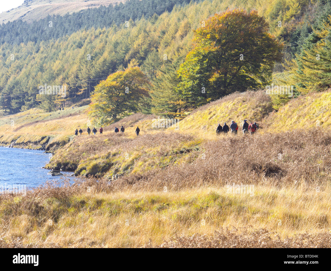 Backpackers walking alongside Yeoman Hey Reservoir, Greenfield, Oldham ...