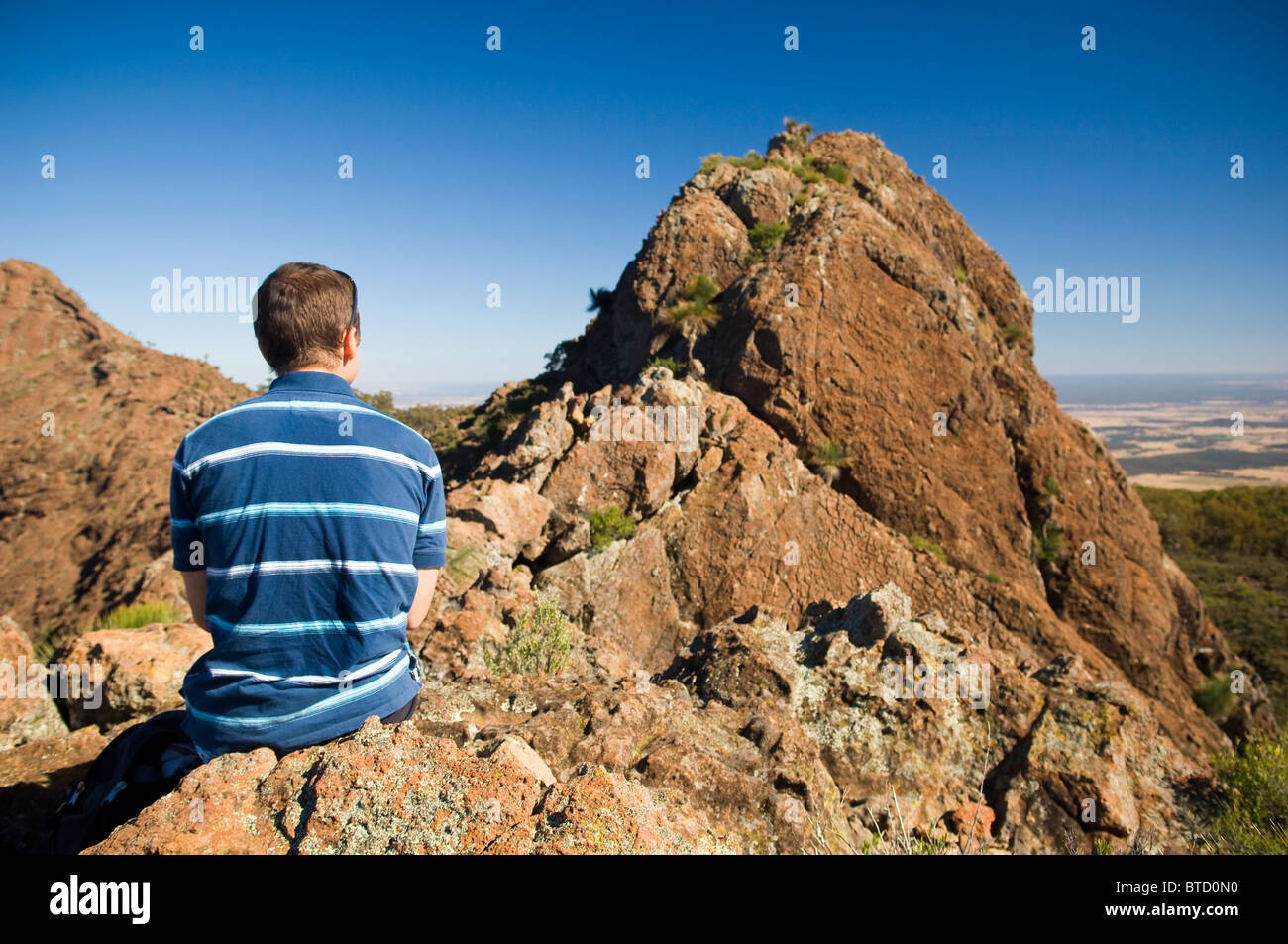 Man sitting on rock ledge hi-res stock photography and images - Alamy