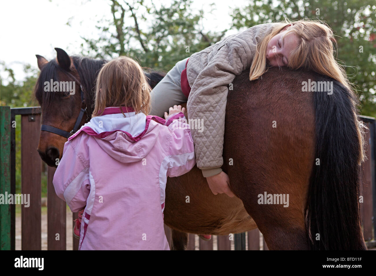 teenage girl lying on a pony Stock Photo - Alamy