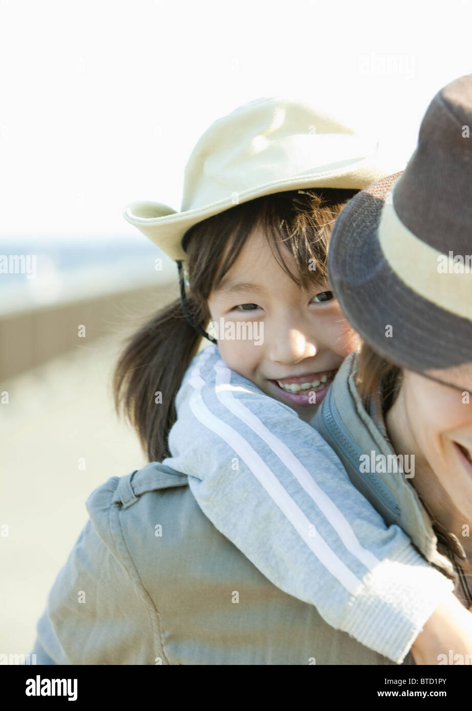 Girl being given piggyback by father Stock Photo - Alamy