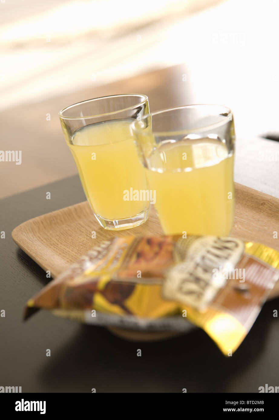 Orange juice and a packet of snack Stock Photo - Alamy