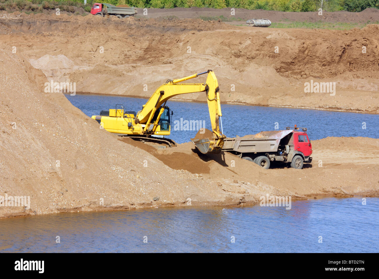 sandpit - excavator dump tipper loads of sand Stock Photo - Alamy