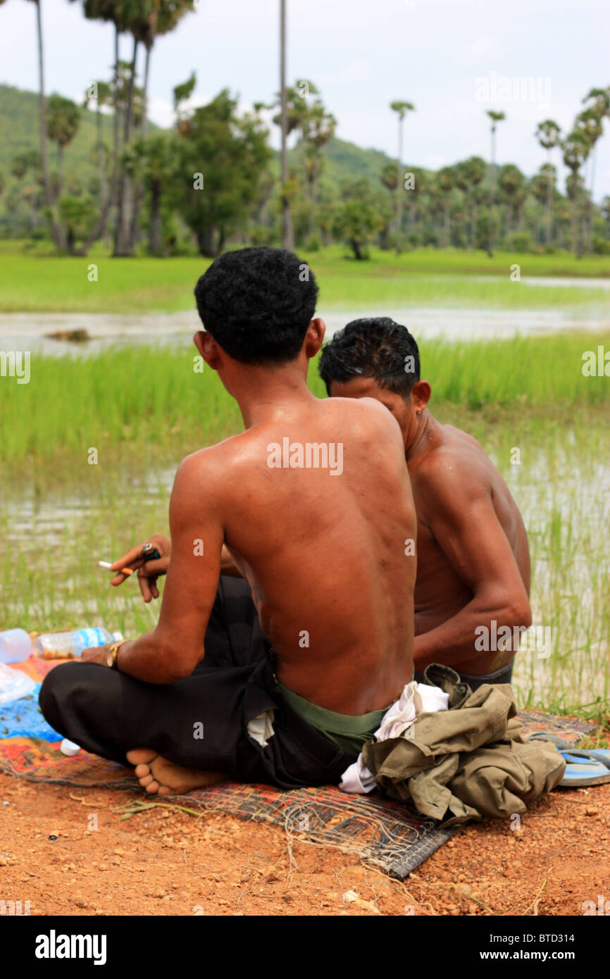 Cambodian people having a rest in rice fields during rain season, asia ...