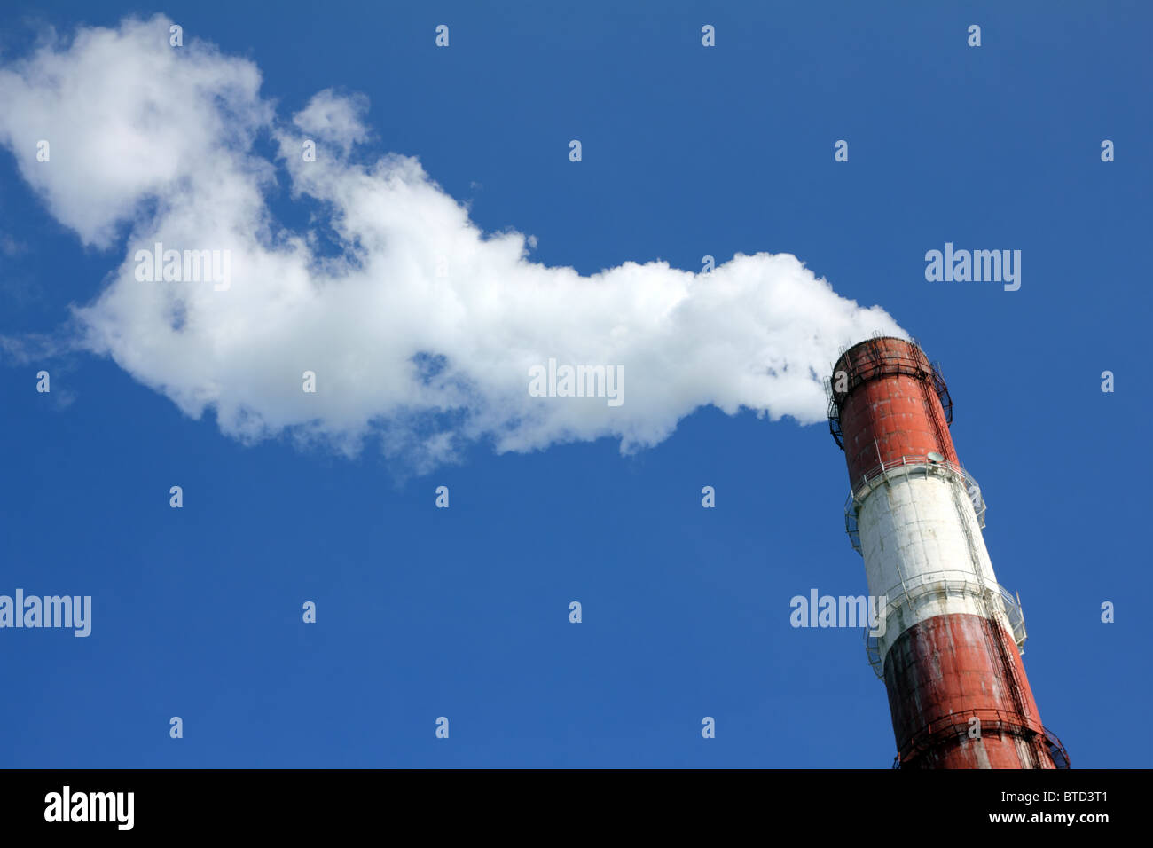 factory chimney with smoke under blue sky Stock Photo - Alamy