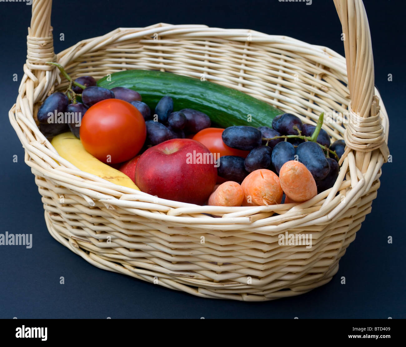 Vegetables and fruits in a basket. Against a dark background Stock ...