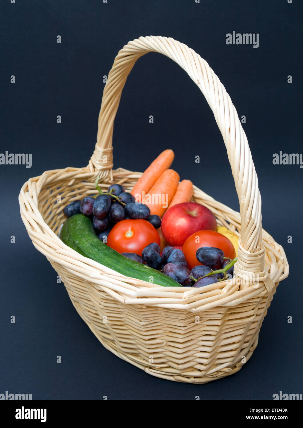 Vegetables and fruits in a basket. Against a dark background Stock ...