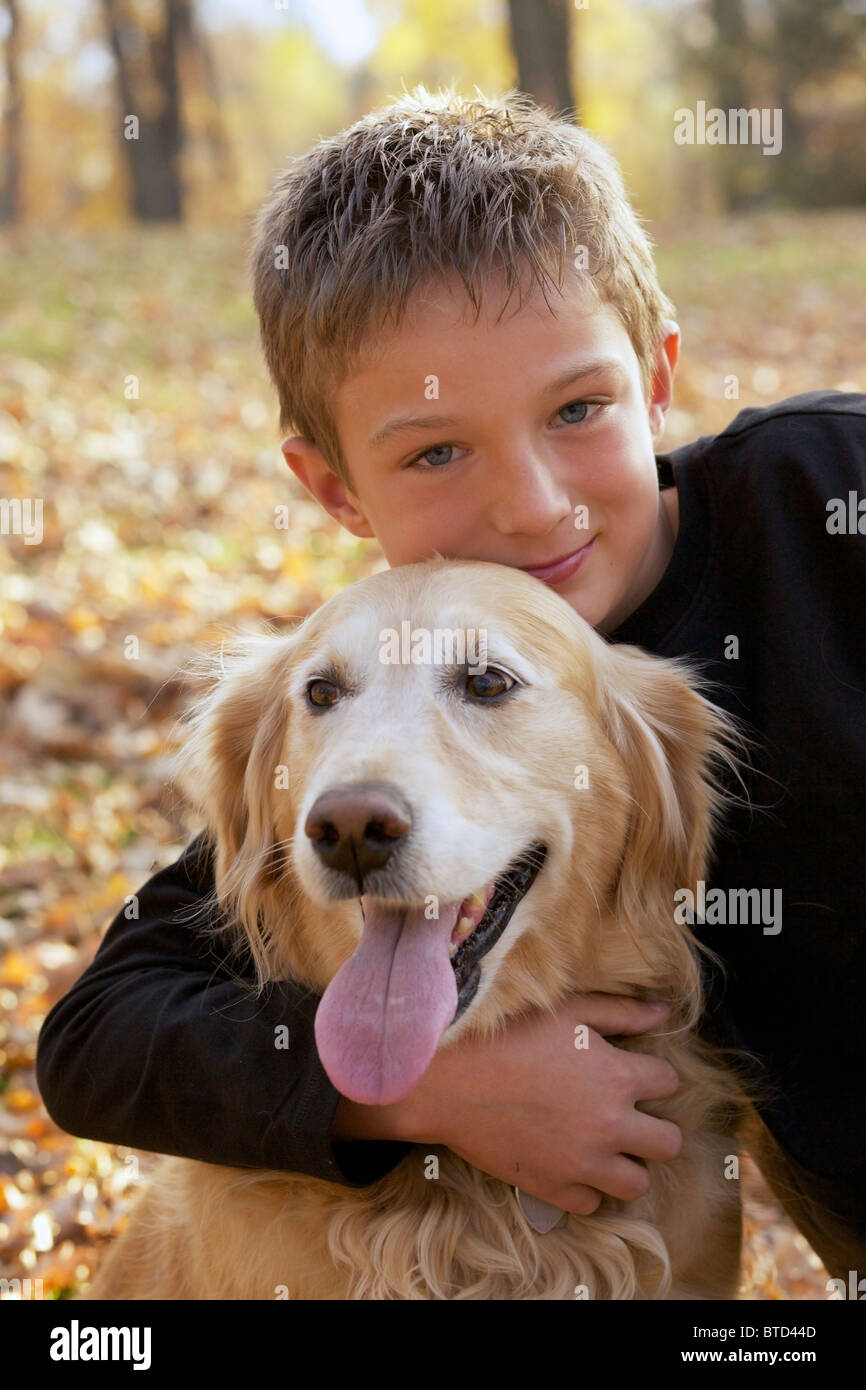Portrait of happy young boy hugging his golden retriever dog Stock ...