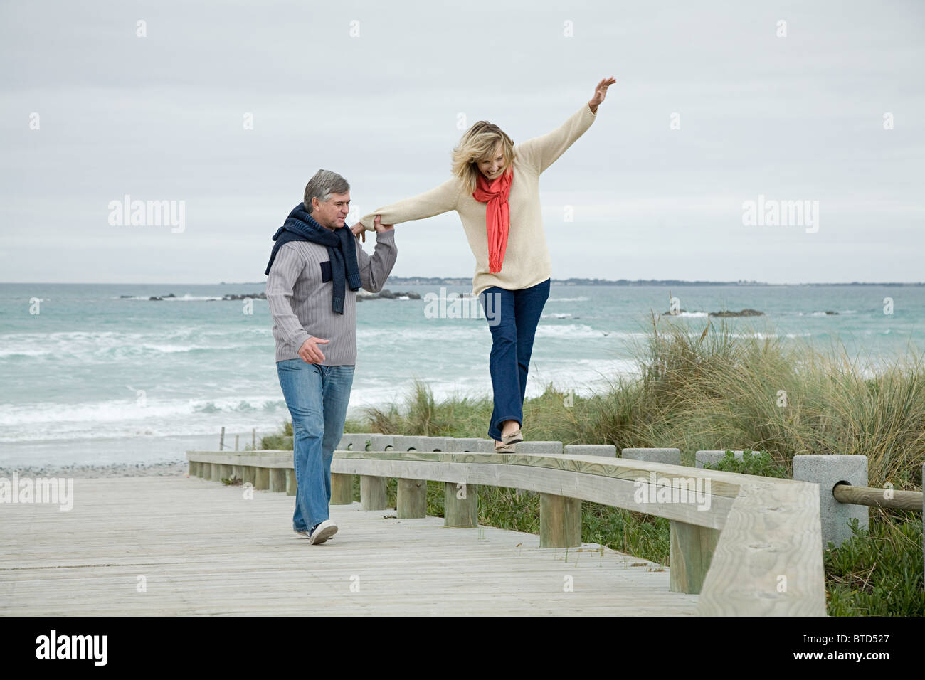 Man helping woman balance on railing Stock Photo - Alamy