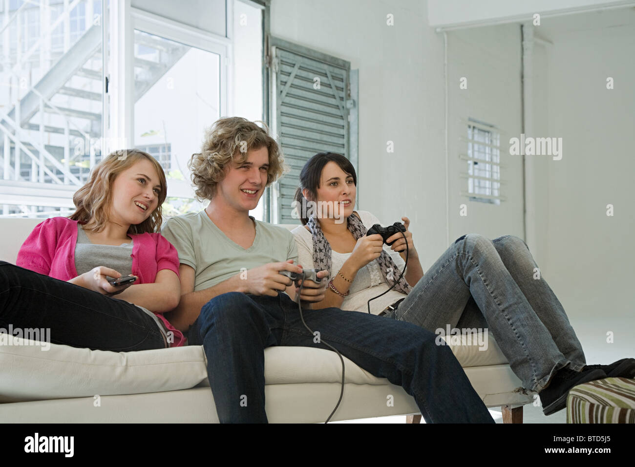 Teenagers playing on games console Stock Photo - Alamy