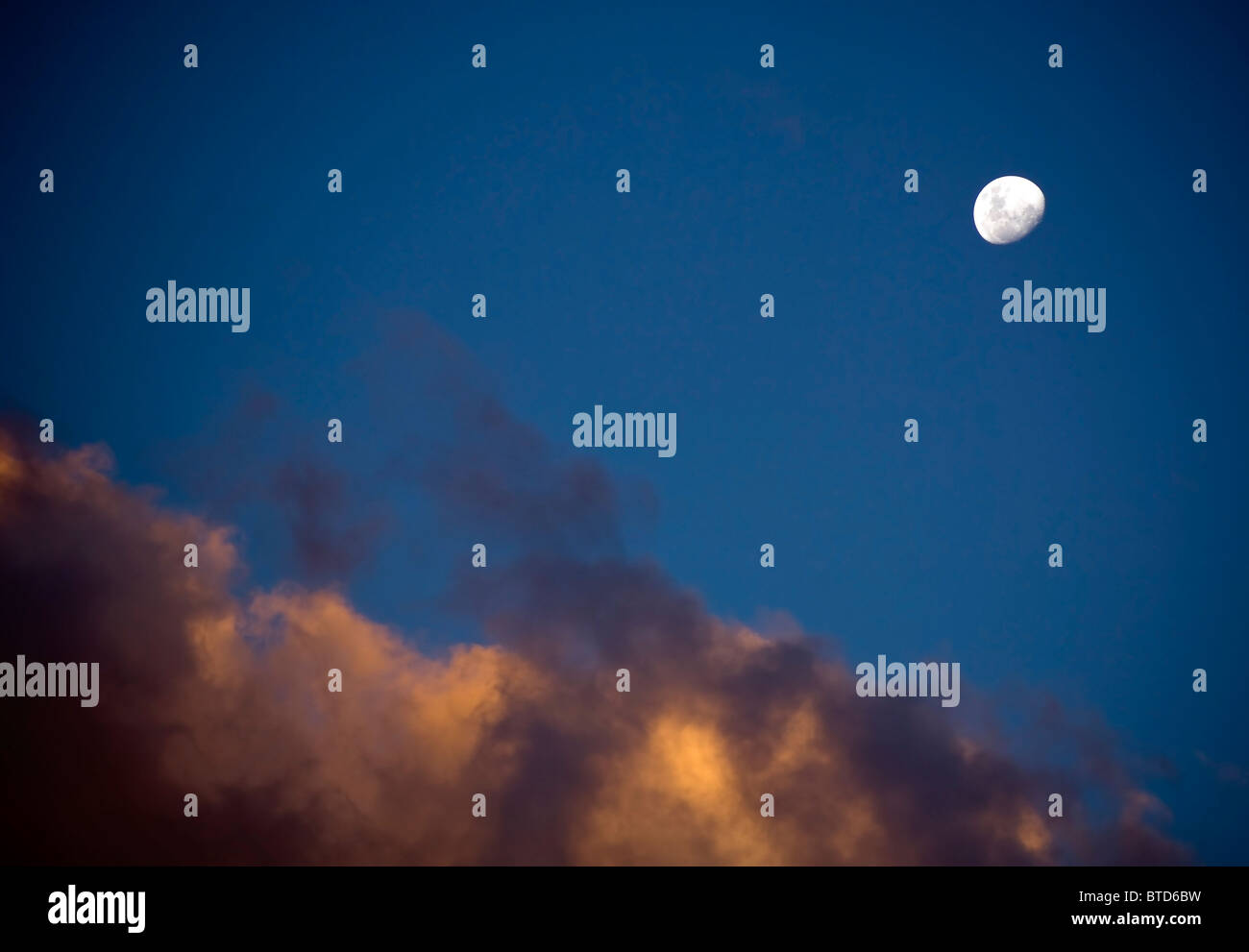 Almost full bright white moon rises over last light in the clouds Stock ...