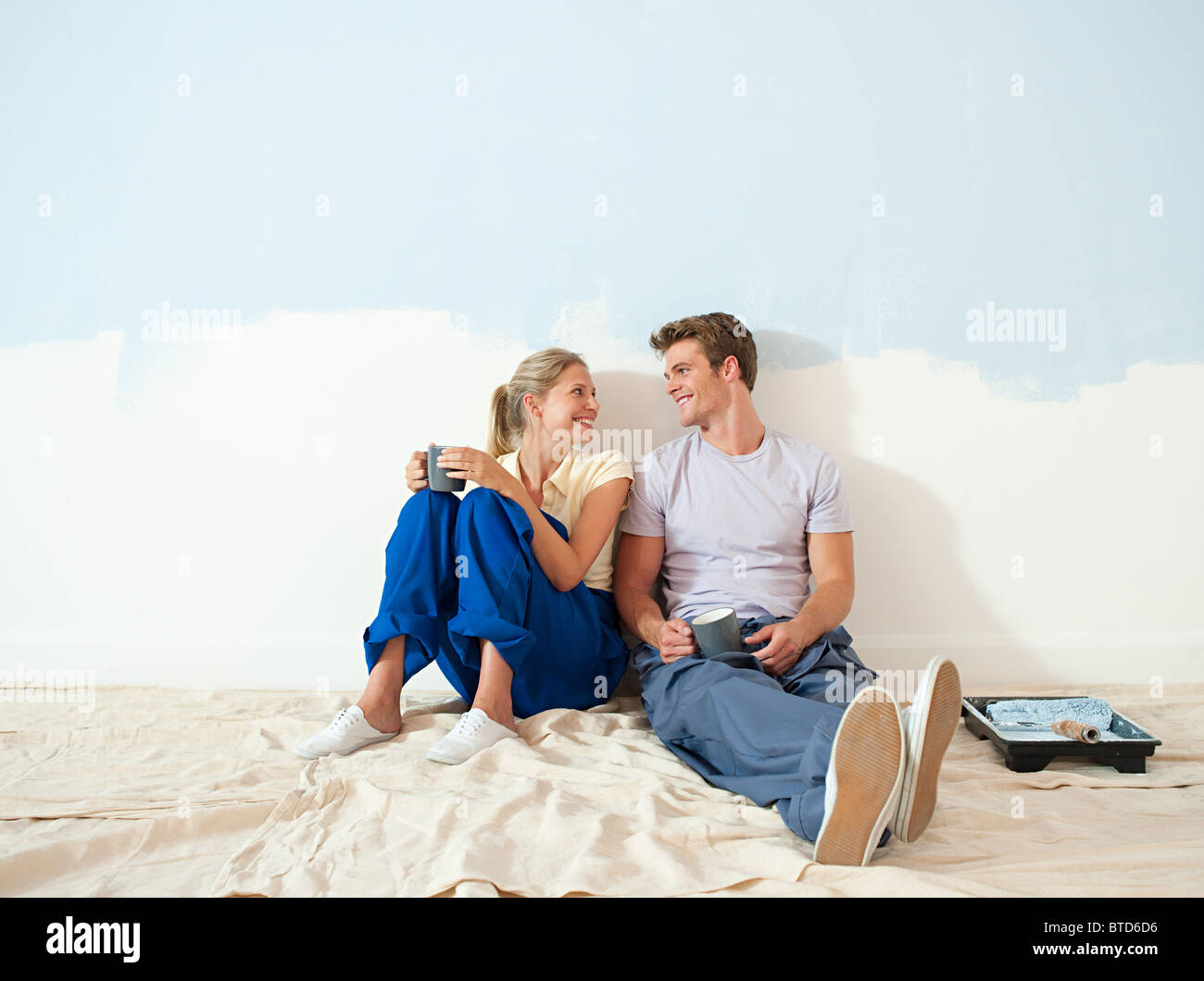 Young couple taking a break from decorating Stock Photo - Alamy