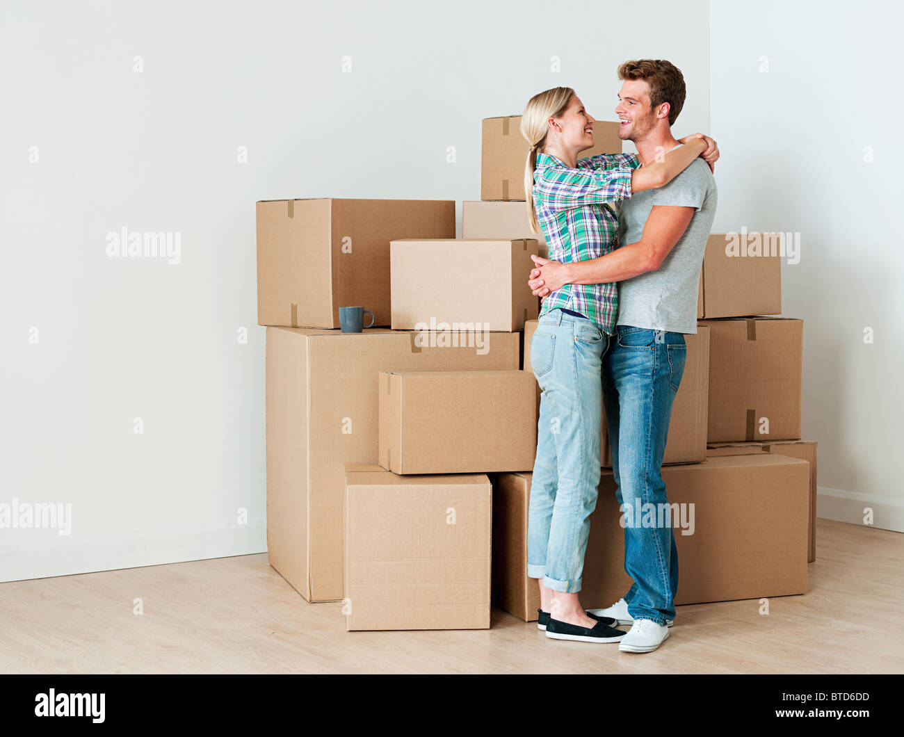 Young couple hugging by cardboard boxes Stock Photo - Alamy