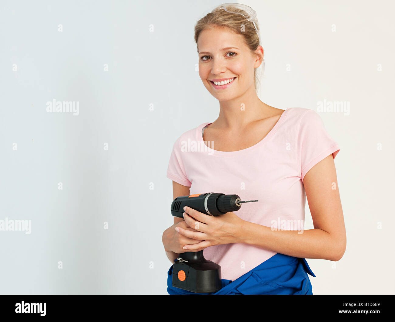 Blond woman holding electric drill hi-res stock photography and images ...