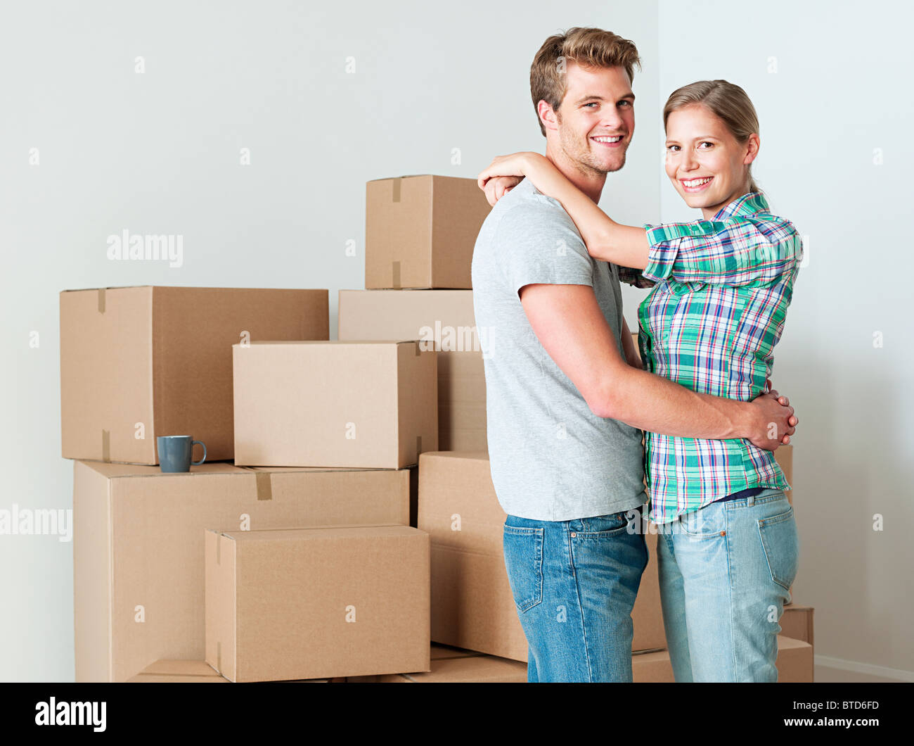 Young couple hugging by cardboard boxes Stock Photo - Alamy