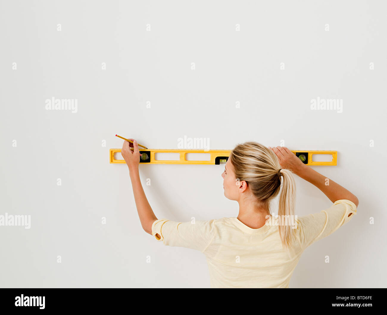 Young woman using spirit level Stock Photo - Alamy