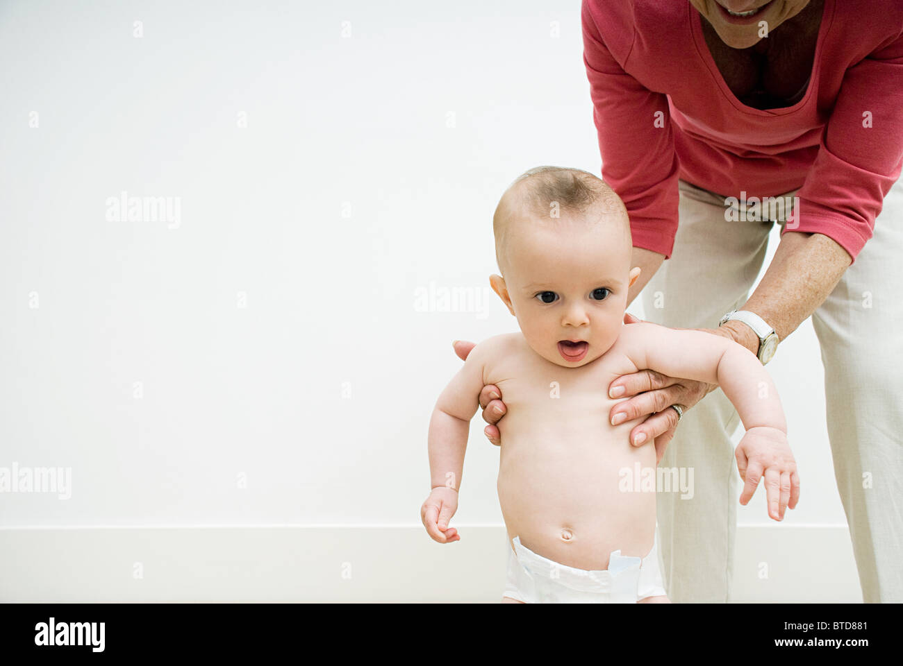 Baby being helped to stand Stock Photo - Alamy