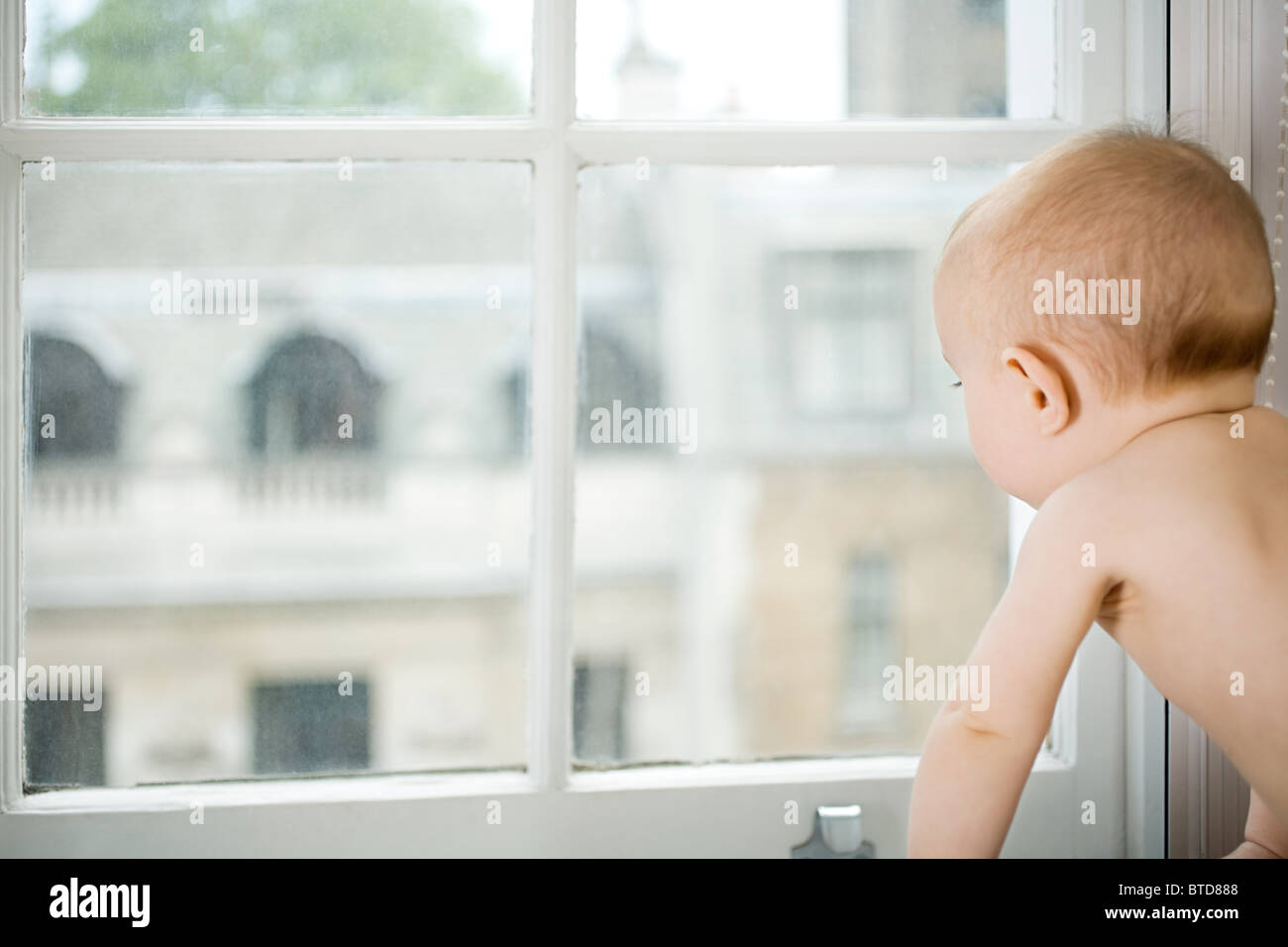 Baby looking out of window Stock Photo - Alamy
