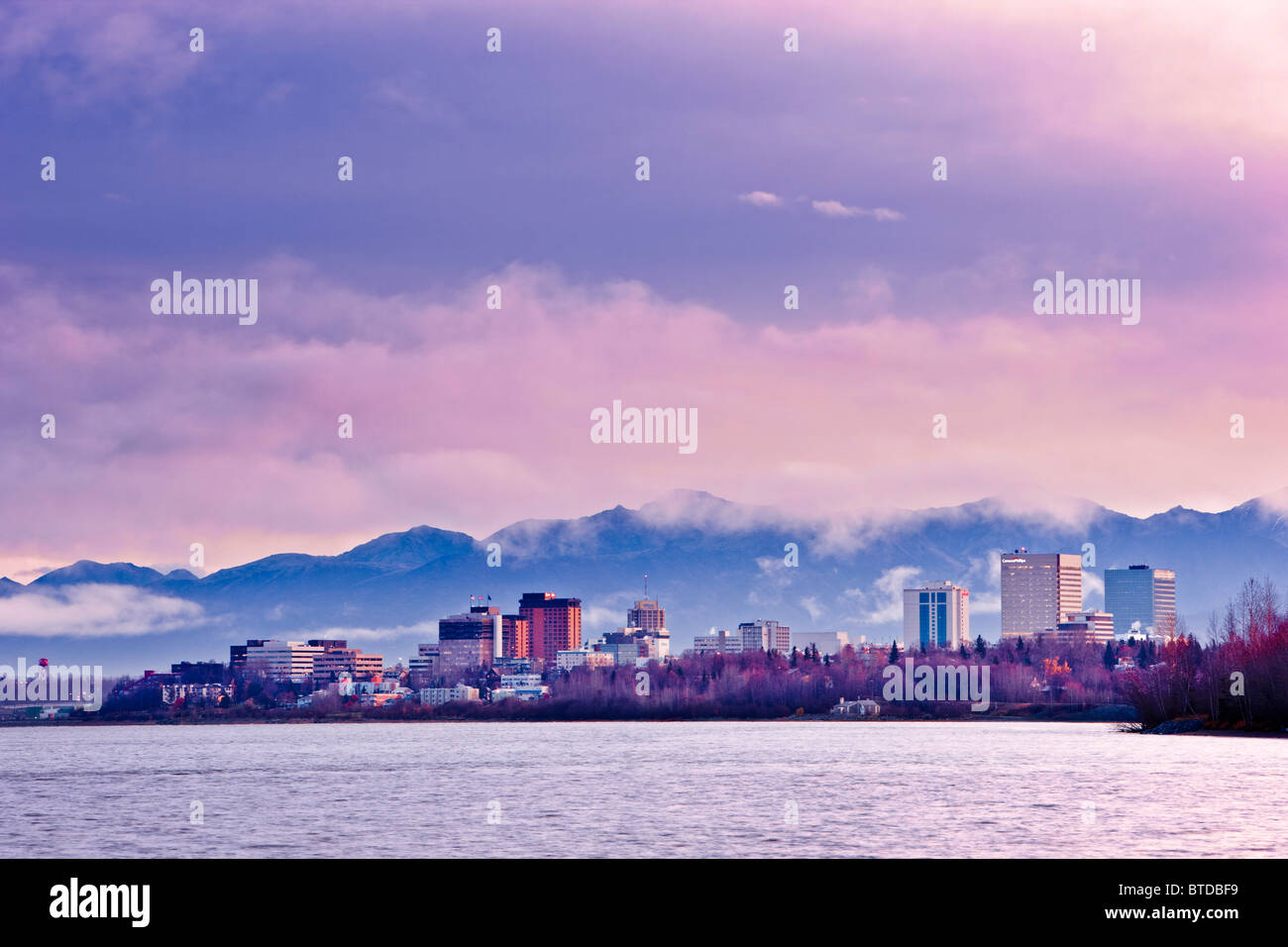 Skyline view of the sun rising over a fog shrouded Anchorage and Cook ...
