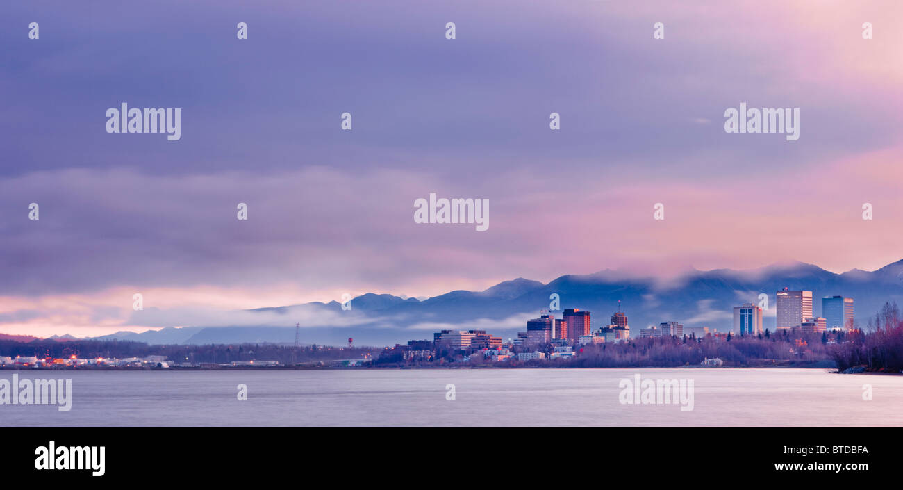 Skyline view of the sun rising over a fog shrouded Anchorage and Cook ...