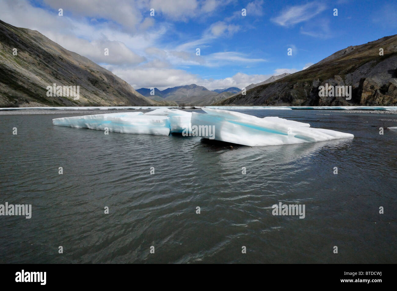 Chunks of river ice, known as aufeis, float in the Kongakut River ...