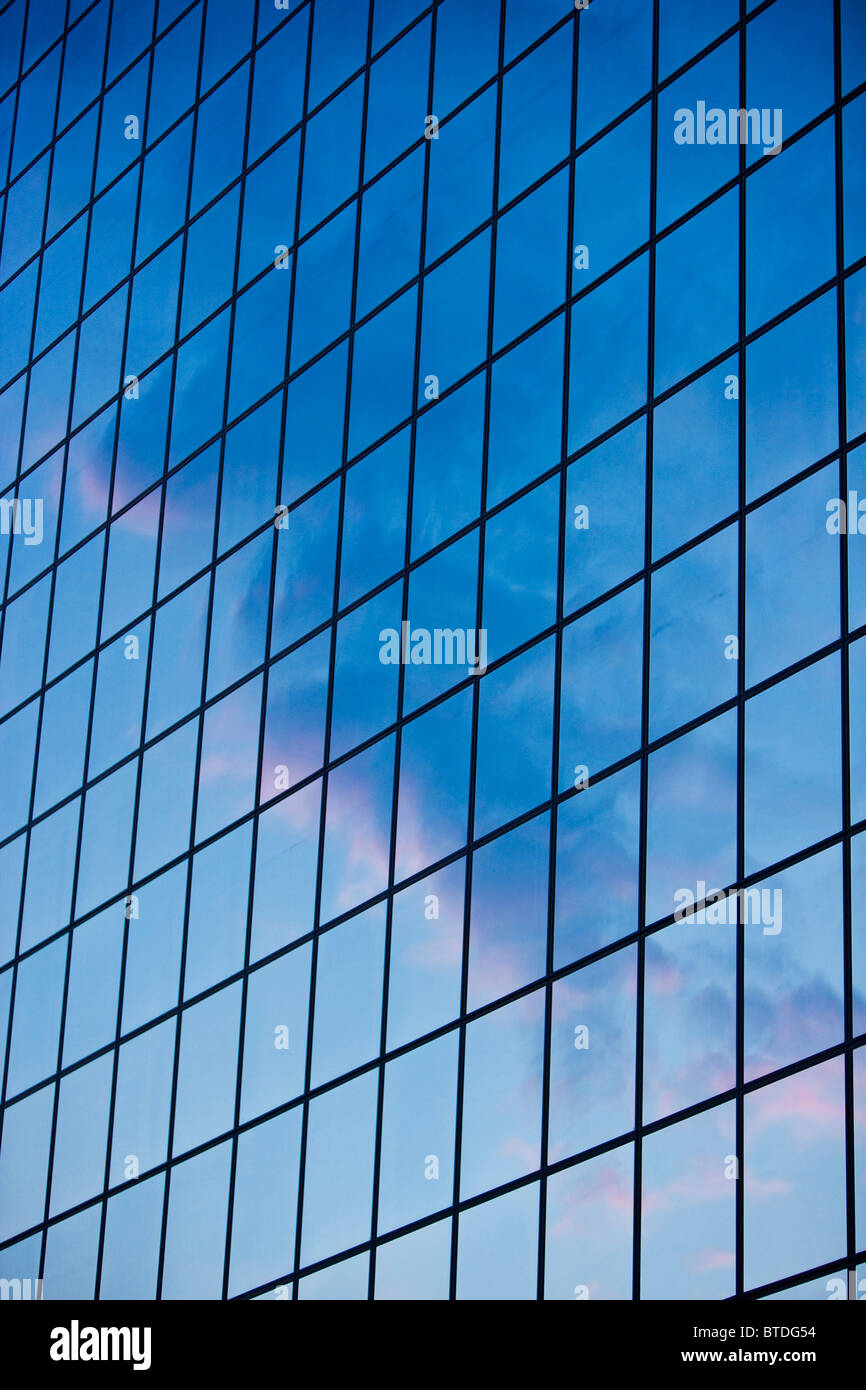 Clouds and sky reflected in windows of an office high rise in downtown ...