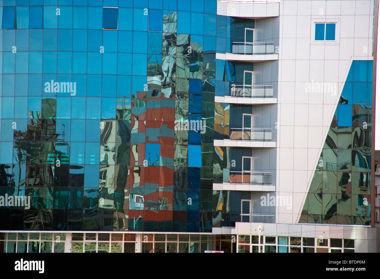 Reflections in the blue glass frontage of a modern building in downtown ...