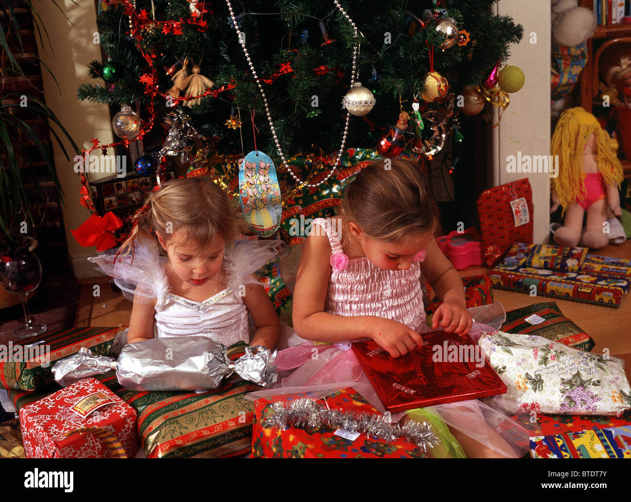 Children unwrapping presents tree hi-res stock photography and images ...